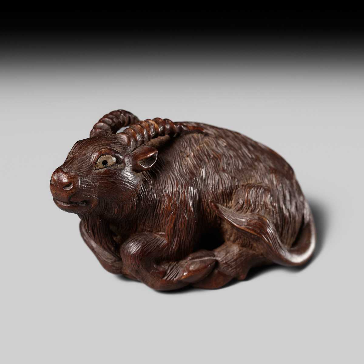 KOKEI: A FINE WOOD NETSUKE OF A RECUMBENT GOAT | Barnebys