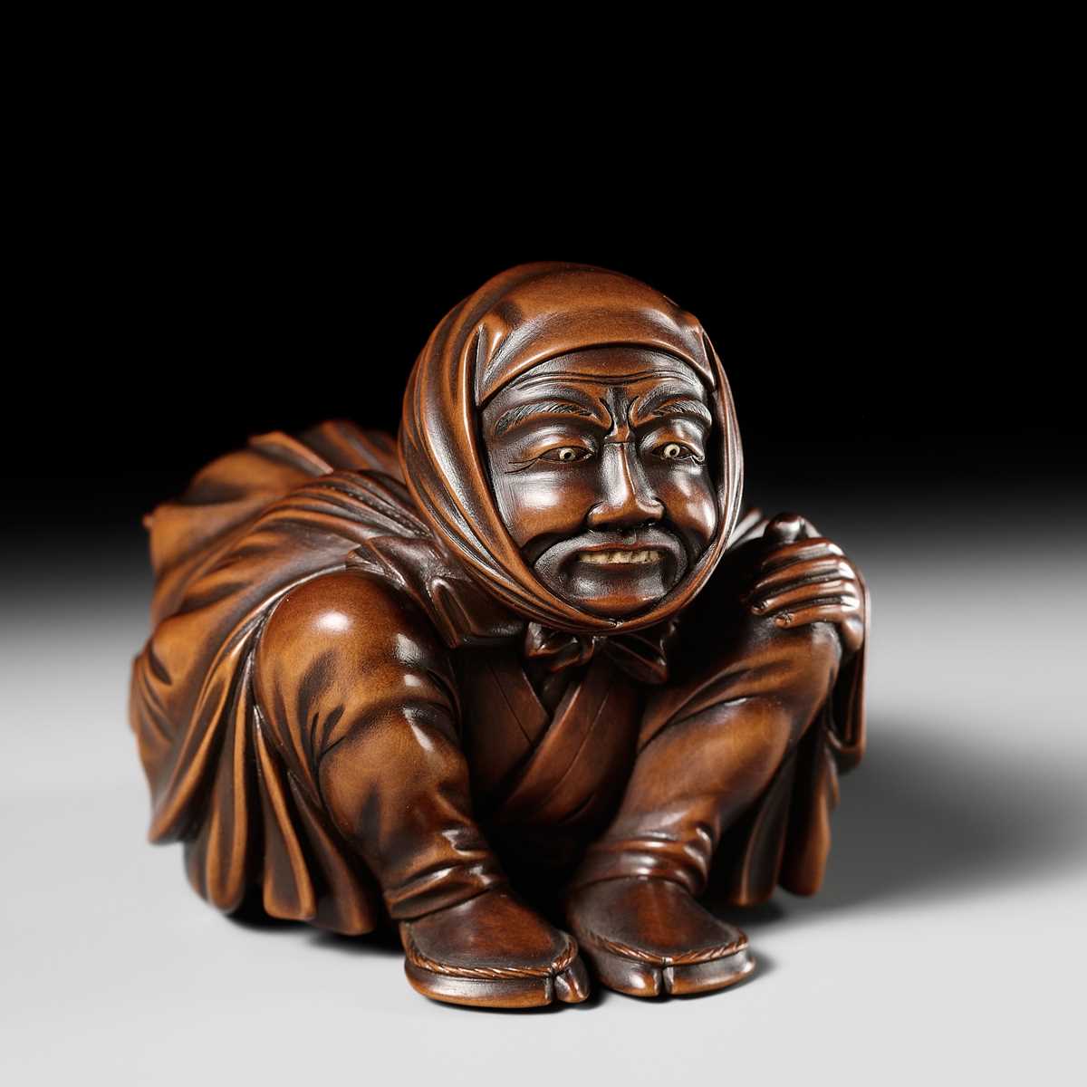 RYUKEI: A LARGE WOOD OKIMONO-STYLE NETSUKE OF A MAN CARRYING A BAG ...