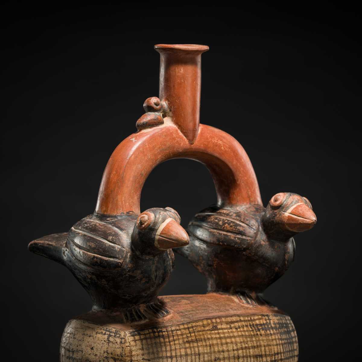 A CERAMIC STIRRUP-SPOUT VESSEL DEPICTING TWO BIRDS ATOP A BALE, MOCHE ...