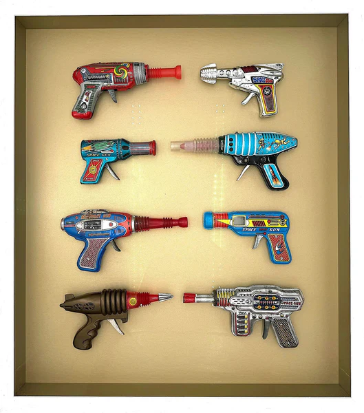A collection of 1960s/70s tinplate and plastic ray guns mounted in ...