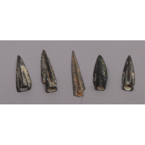 A bronze lozenge shaped double ridged arrow head, 2,5cm; a b... | Barnebys