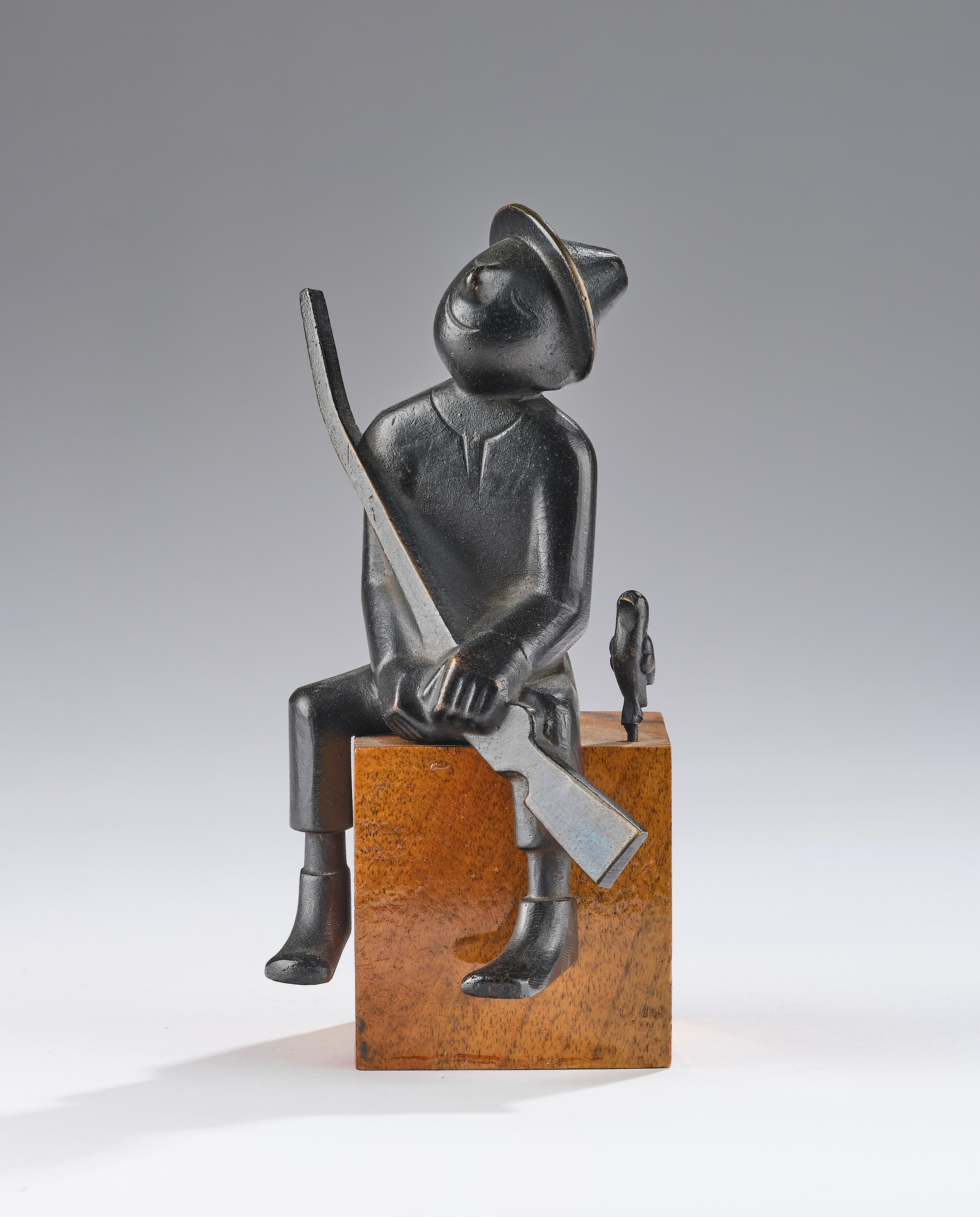 A seated hunter sleeping with a gun and a bird, Werkstätte Hagenauer ...